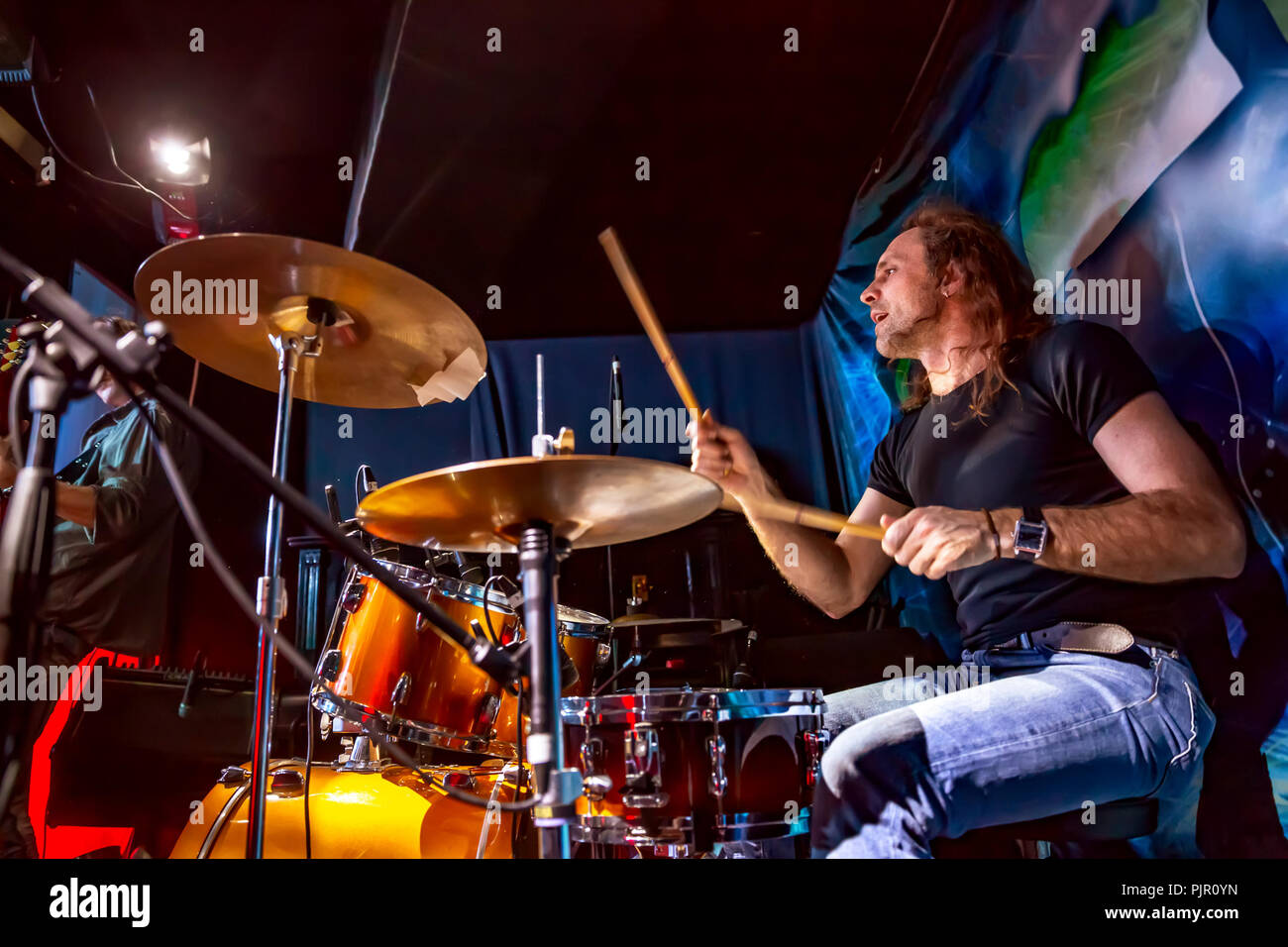 Drummer playing on drum set on stage. Authentic shooting with high iso ...