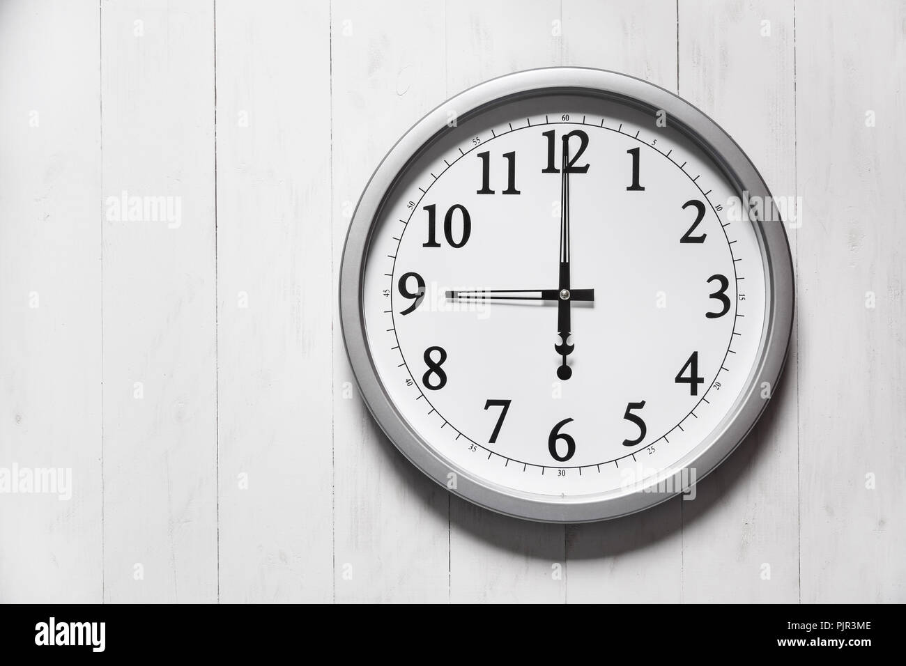 Clock on color wooden plank wall. 9 o'clock Stock Photo - Alamy