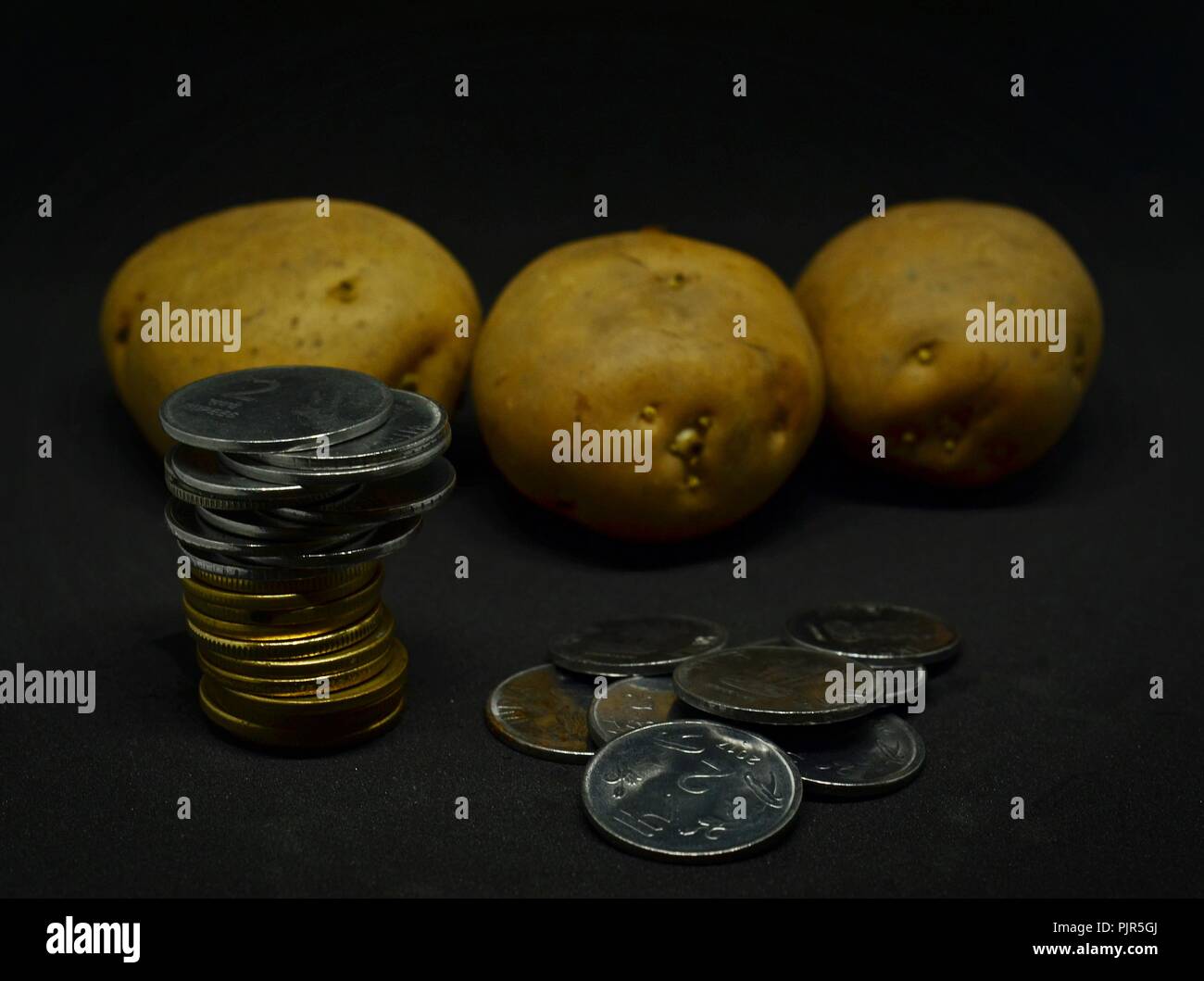 Piled potatos with lots of indian rupee coins Stock Photo - Alamy