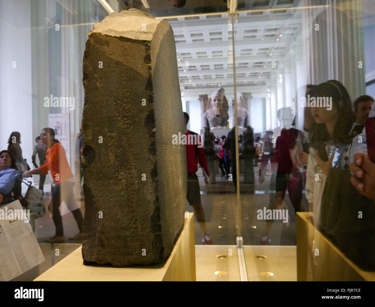 Visitors to the British Museum in London look at the Rosetta stone ...