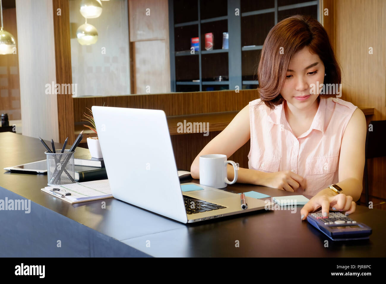 Business woman calculate finance data with calculator and laptop ...