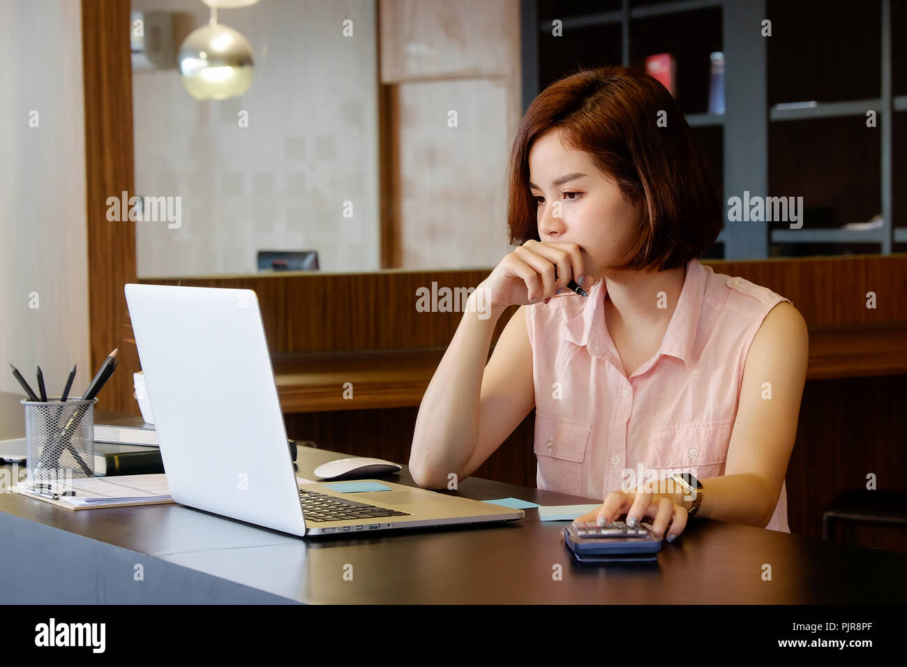 Business woman calculate finance data with calculator and laptop ...