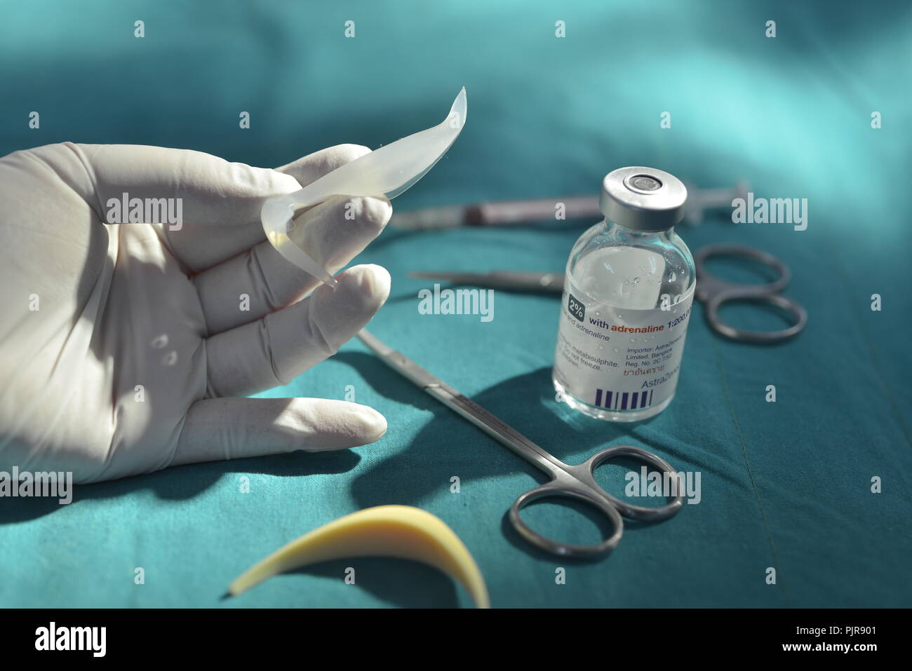 Hand holding silicone nasal implant in operating room with surgical ...