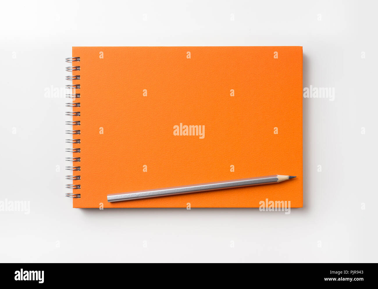 Design concept - Top view of orange spiral notebook and color pencil ...