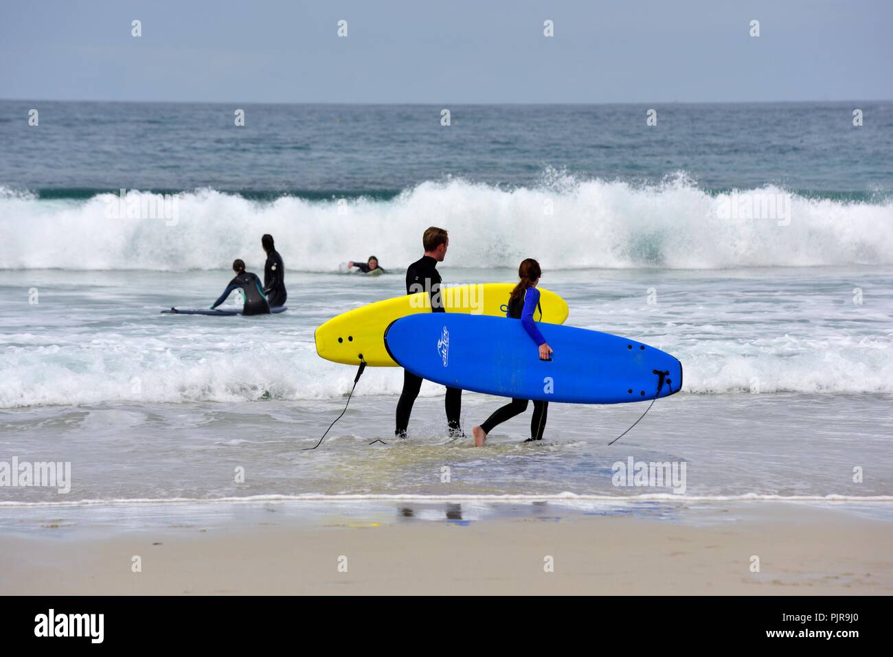 Young people carrying surf boards hi-res stock photography and images ...