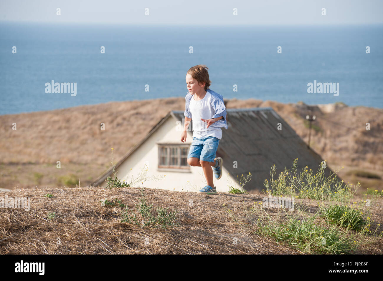 cute little caucasian boy running fast outdoors autumn sea and old ...