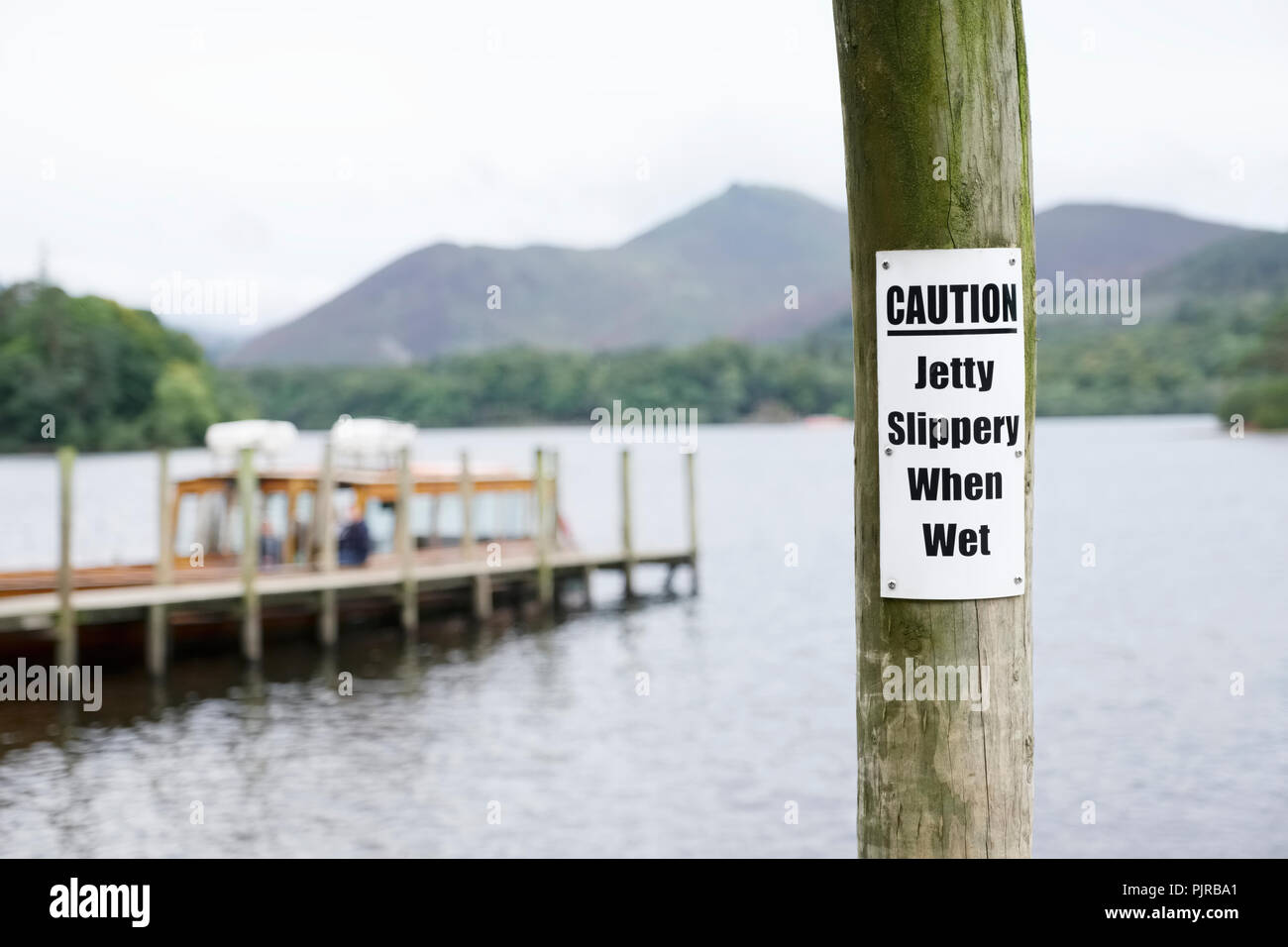 Jetty pier water safety sign slippery when wet at Derwentwater in the ...