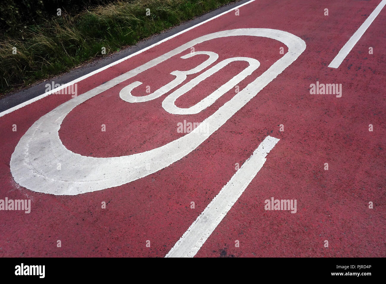 massive 30 symbol on a red covered road in 30 miles an hour speed limit ...