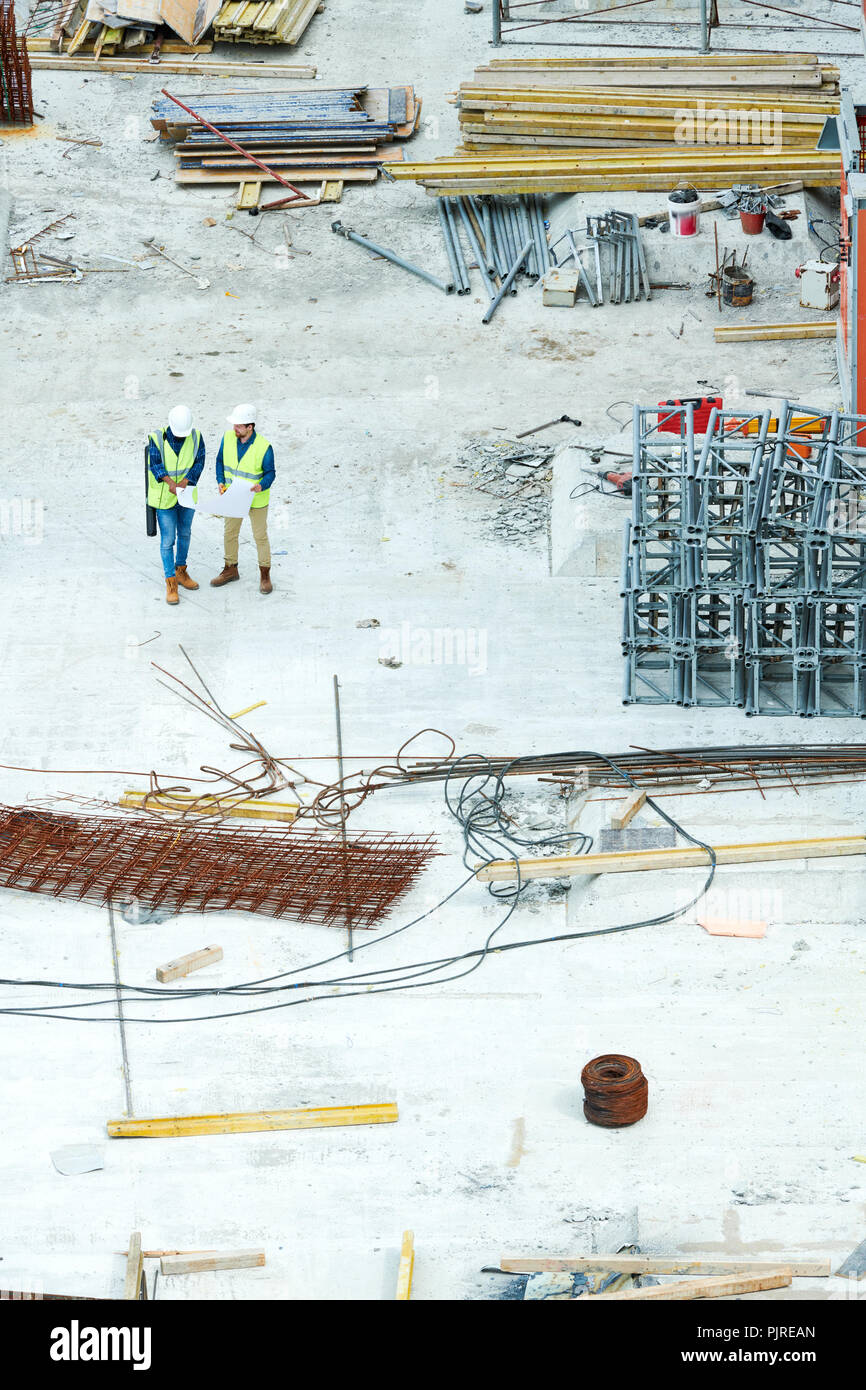 Engineers discussing blueprint construction hi-res stock photography ...