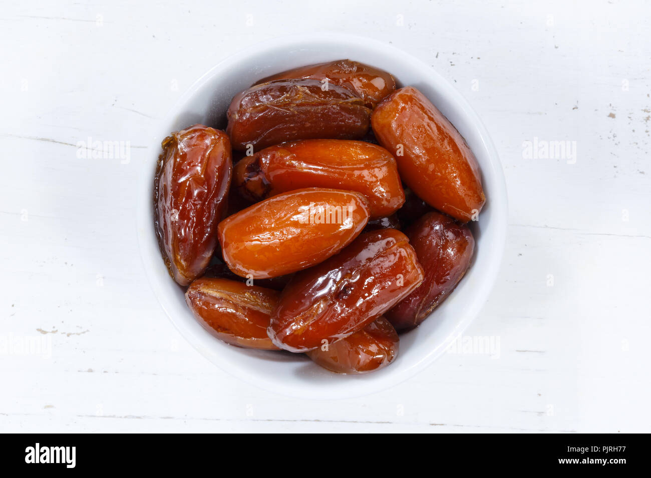 Dates fruit date from above bowl wooden board wood Stock Photo - Alamy
