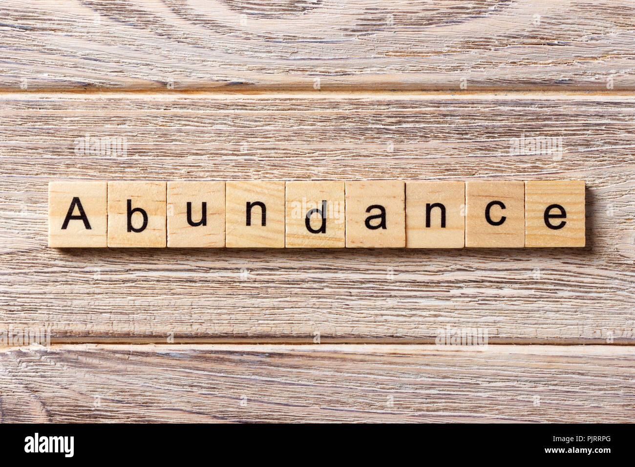 abundance word written on wood block. abundance text on table, concept ...