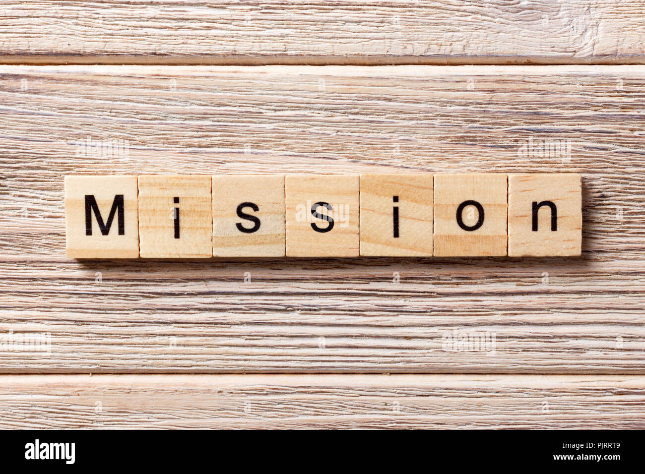 MISSION word written on wood block. MISSION text on table, concept ...