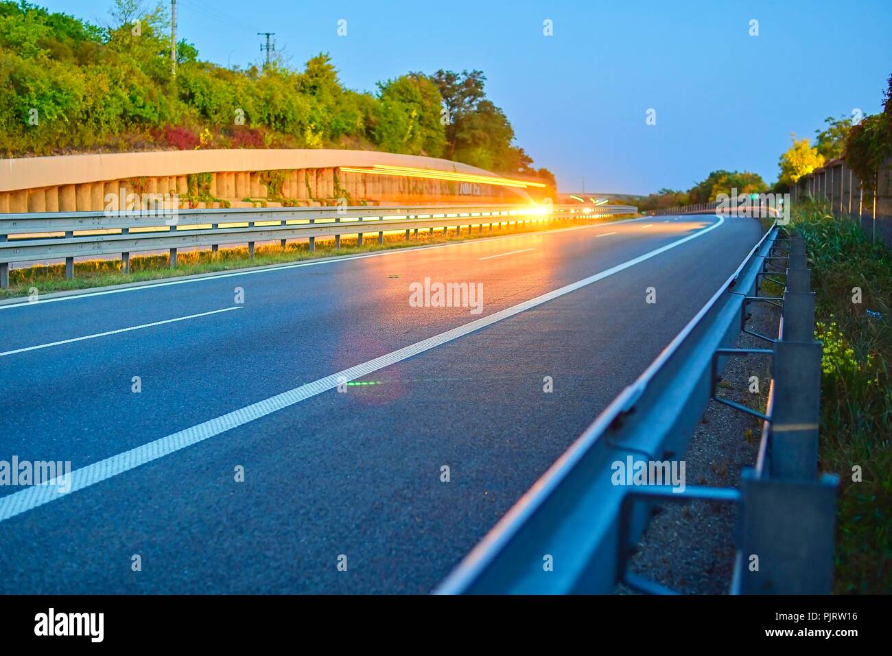 Highway at twilight with light trails. High traffic road with ...