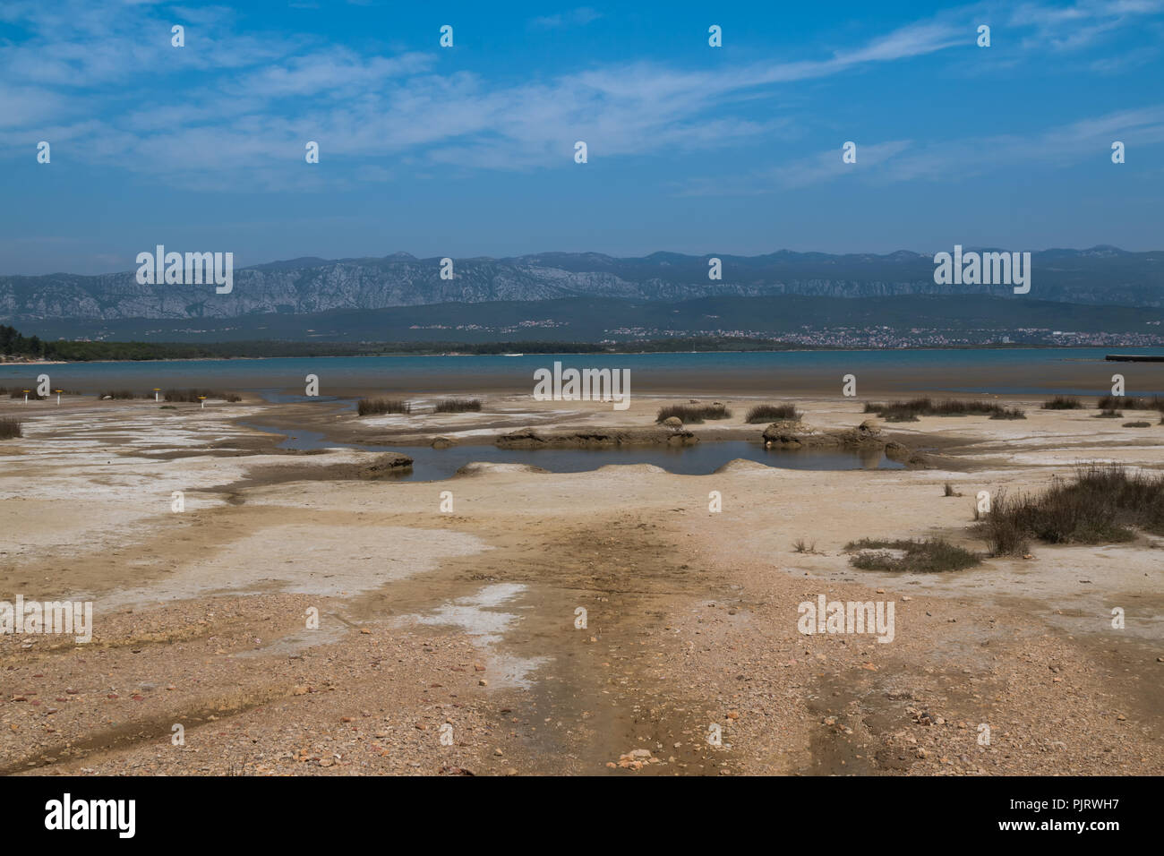 Sandy beach at the coast of the Adriatic sea. Puddles from the high ...