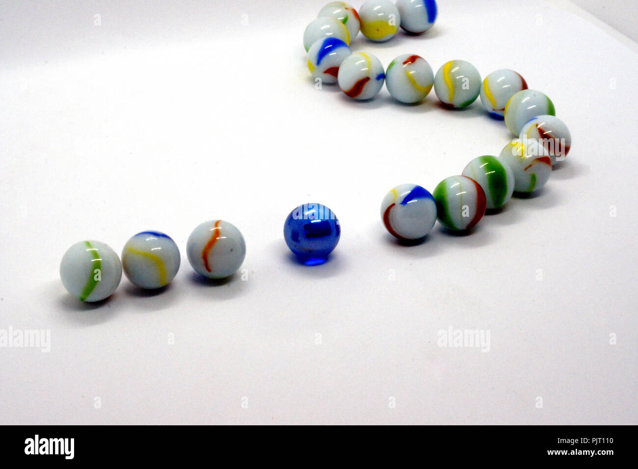 one blue marble in queue under white marbles Stock Photo - Alamy