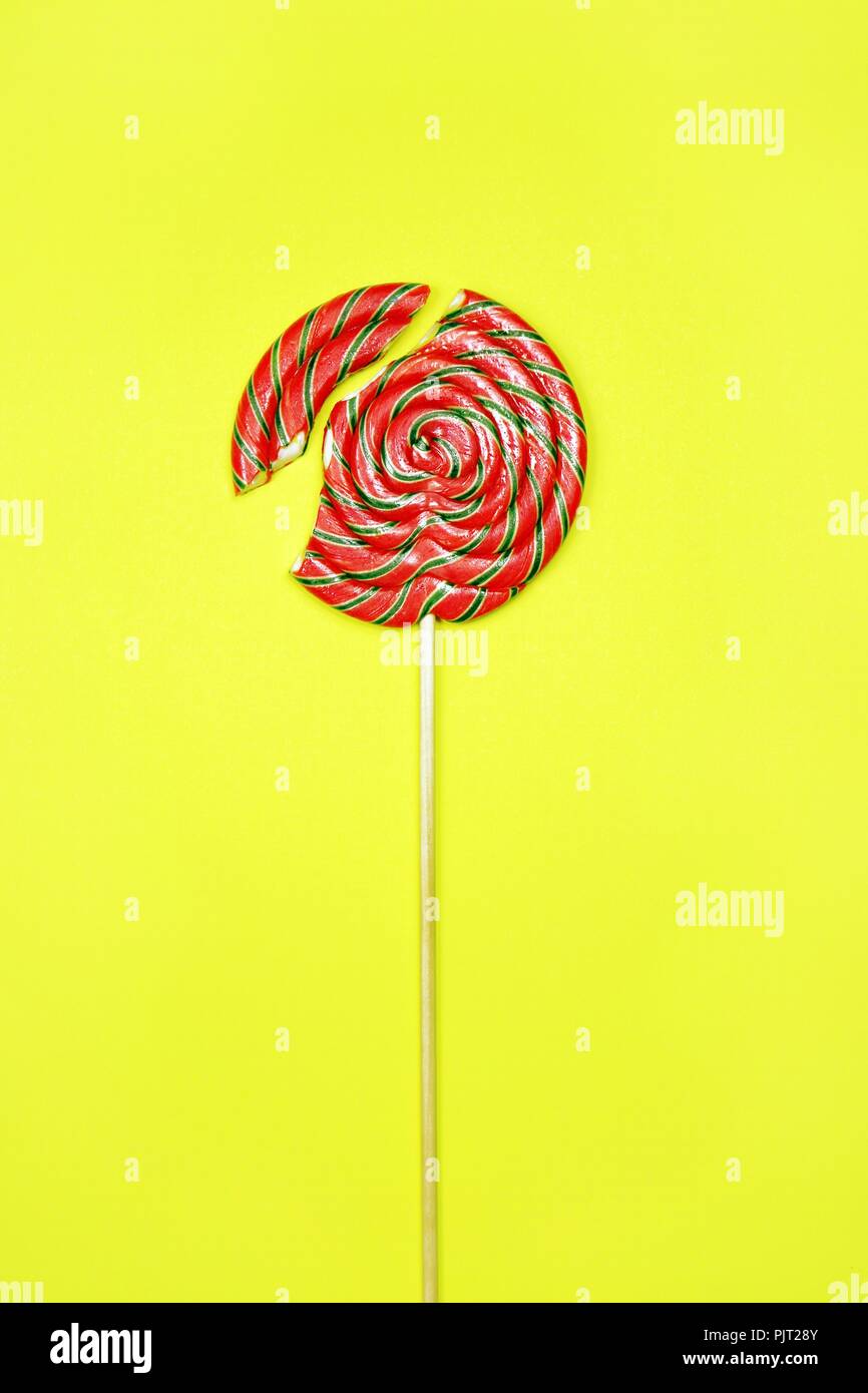 Broken lollipop on yellow background, top view Stock Photo - Alamy