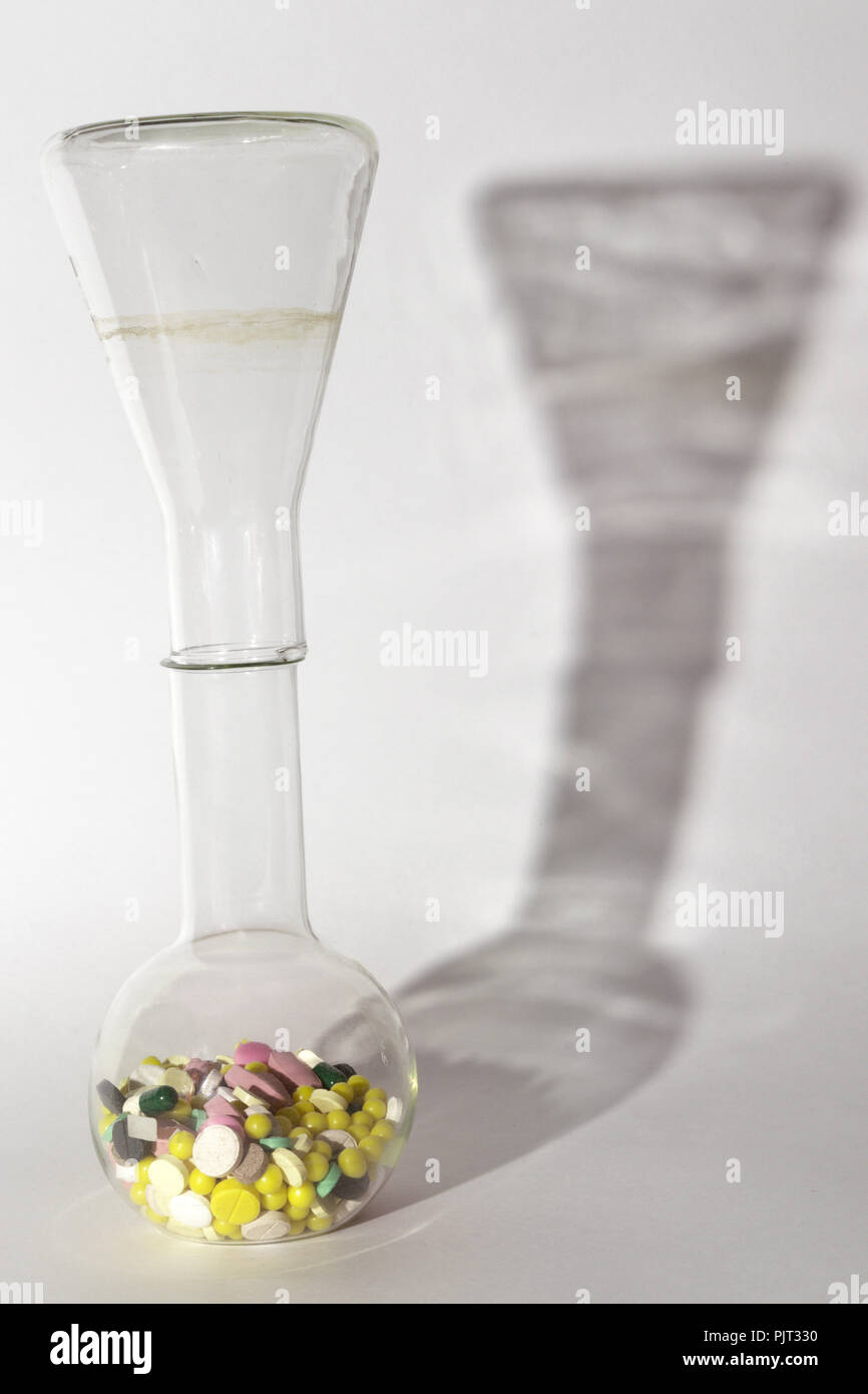 colorful tablets are transmitted in lab flasks. glass vessels ...