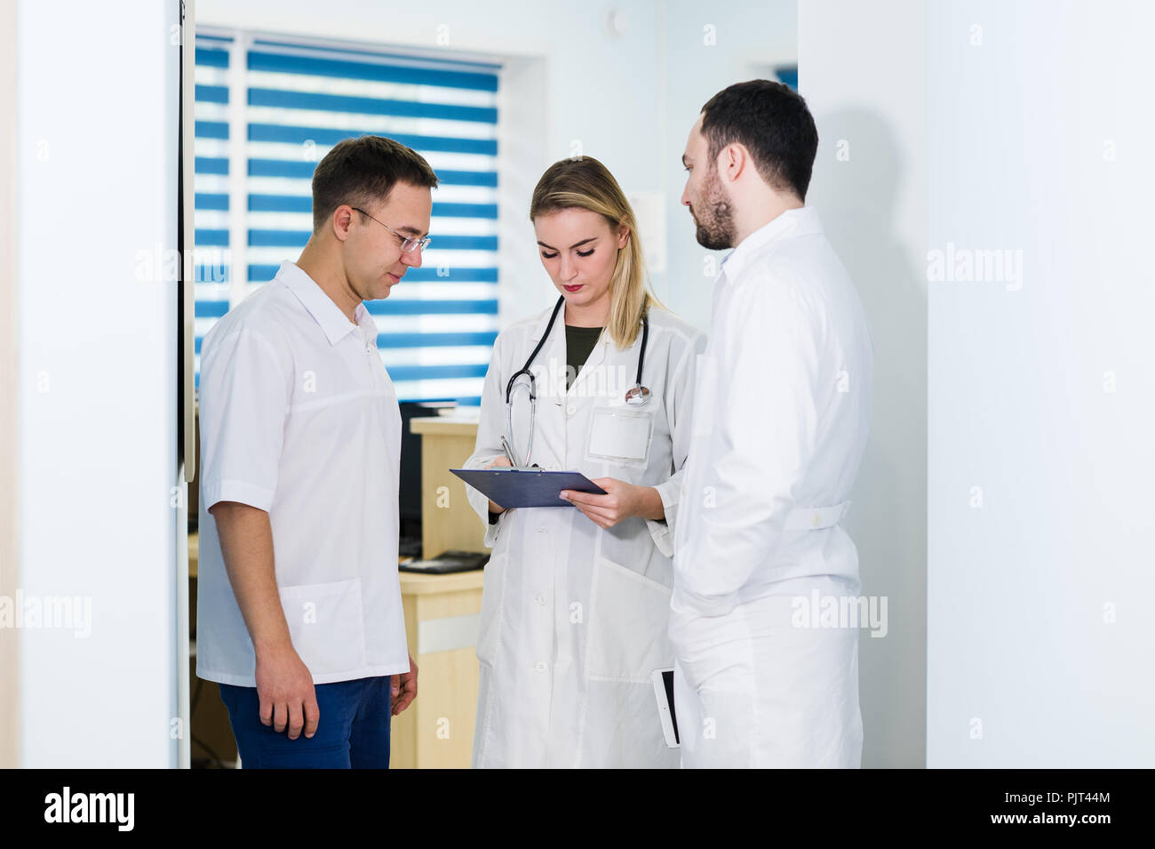 Doctors working in hospital and discussing over medical reports ...