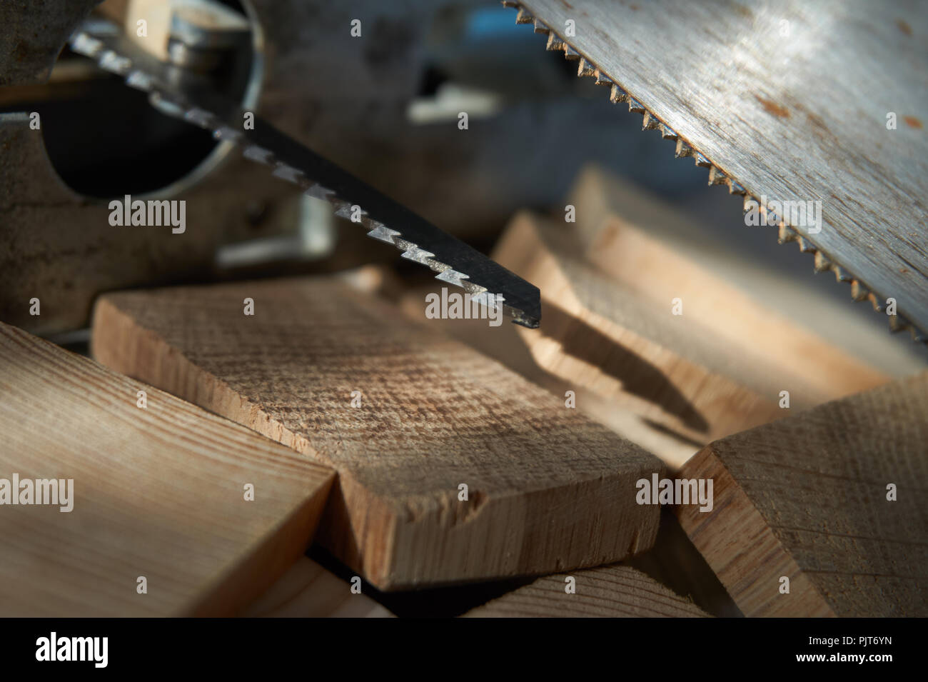 Close up electric jigsaw and hand saw blades above wooden bricks Stock ...