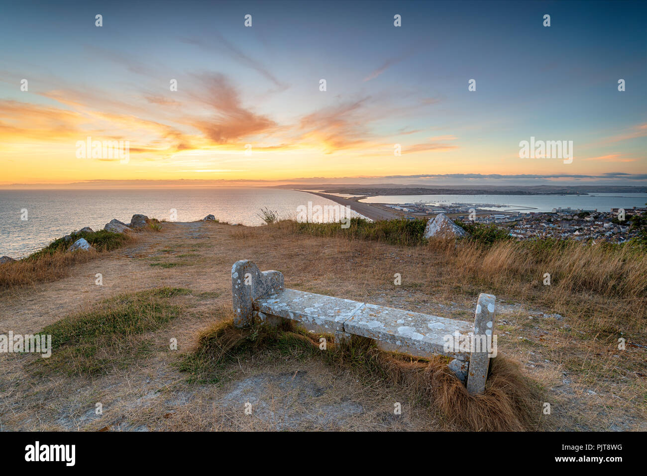 Sunset over an old stone bench on cliffs at Tout Quarry on th e Isle of ...