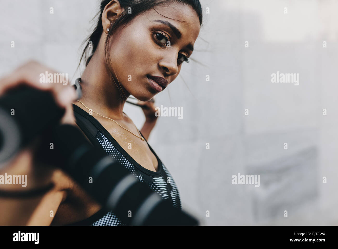 Woman doing workout using a skipping rope. Female athlete standing ...