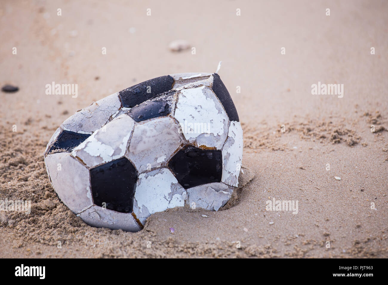 Football old, torn and dirty marks were left on the beach Stock Photo ...