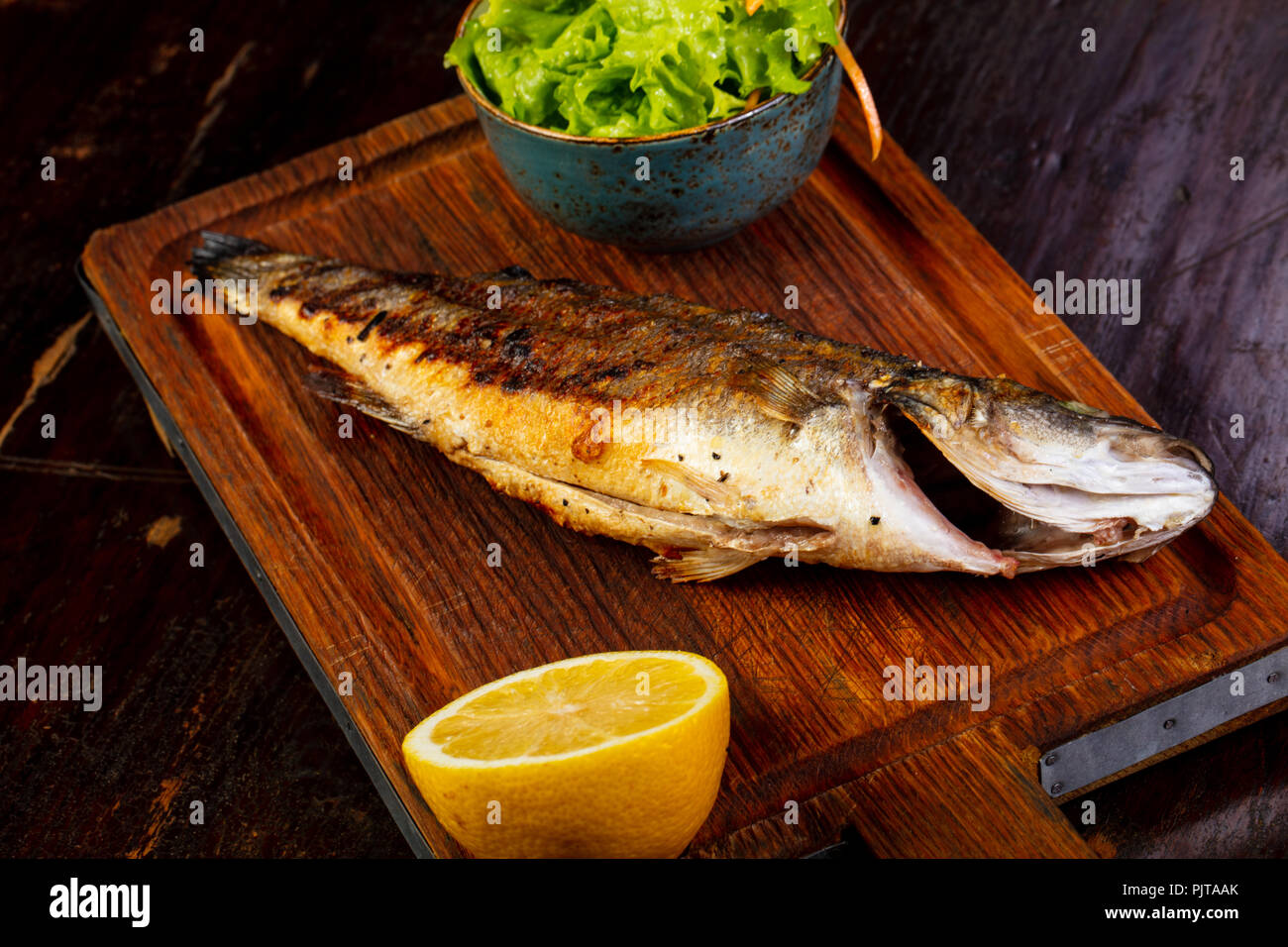 Grilled seabass fish with lemon Stock Photo - Alamy