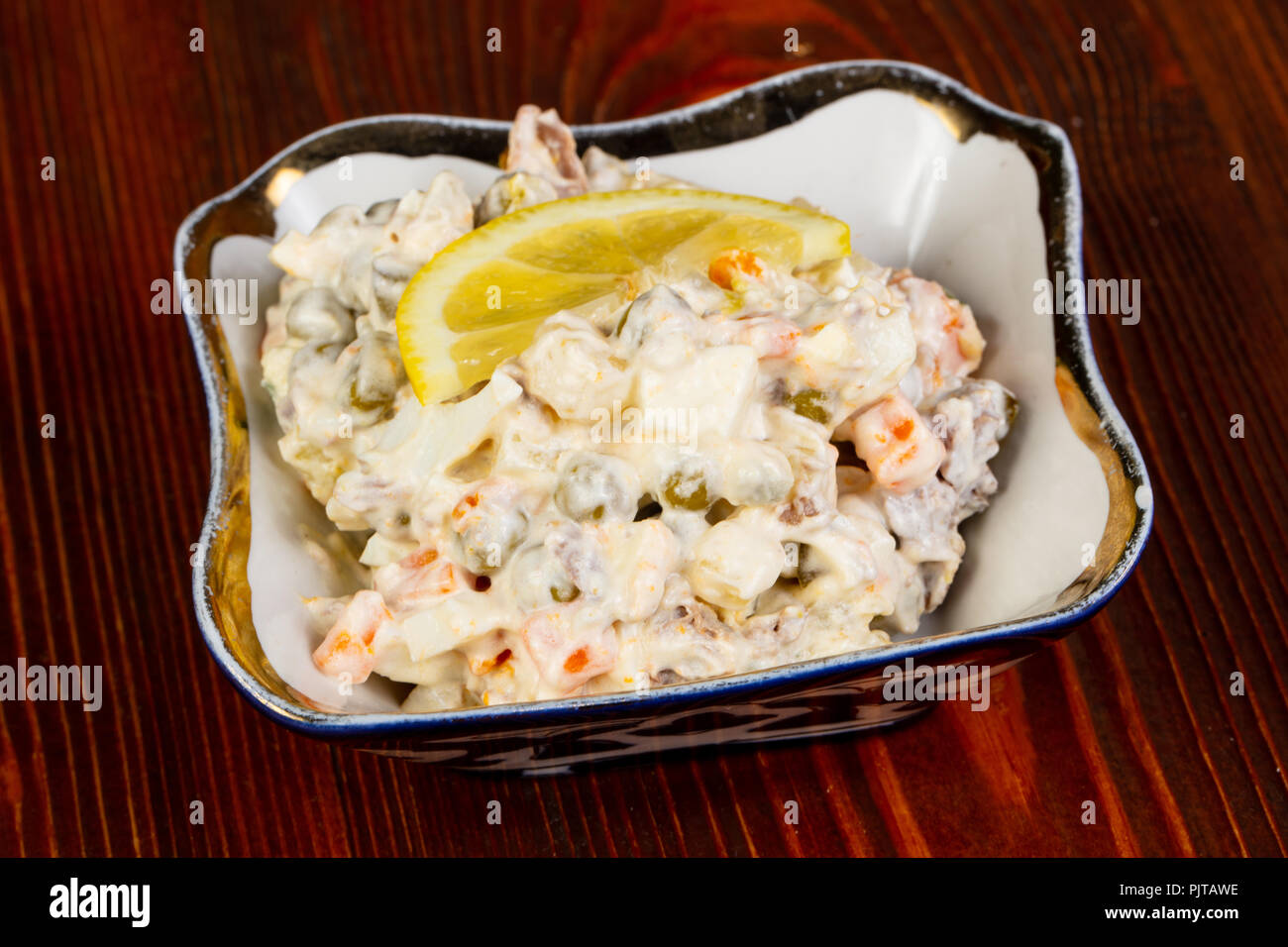 Traditional Russian salad served lemon Stock Photo - Alamy