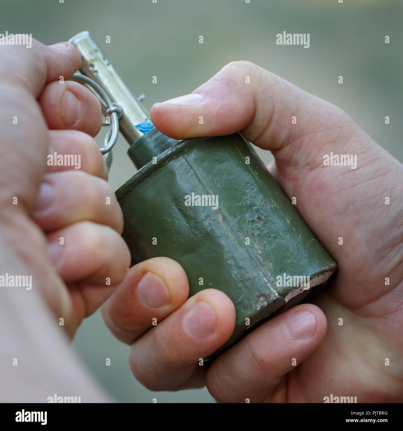 Old antipersonnel grenade in the hands of a man Stock Photo - Alamy