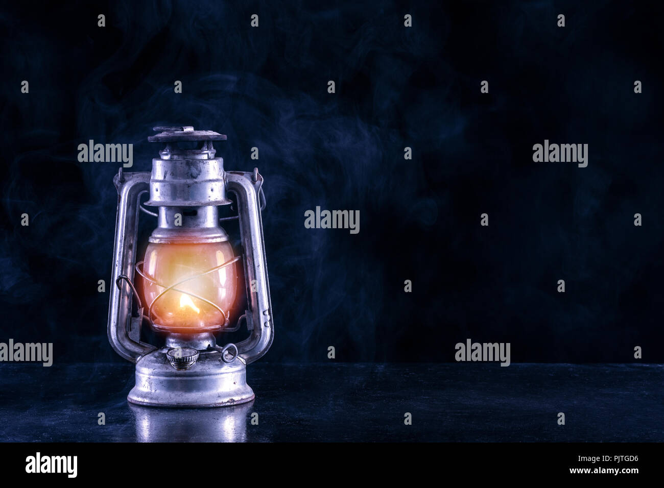 Old gas lamp on black table and foggy and smoke dark and night scenery ...