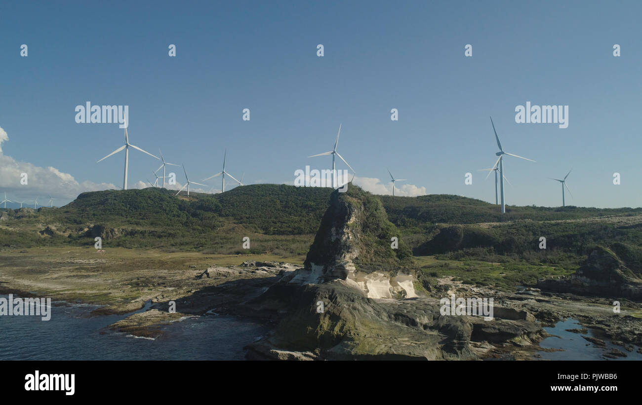 Natural rock formation of limestone stone on the coast with windmills ...
