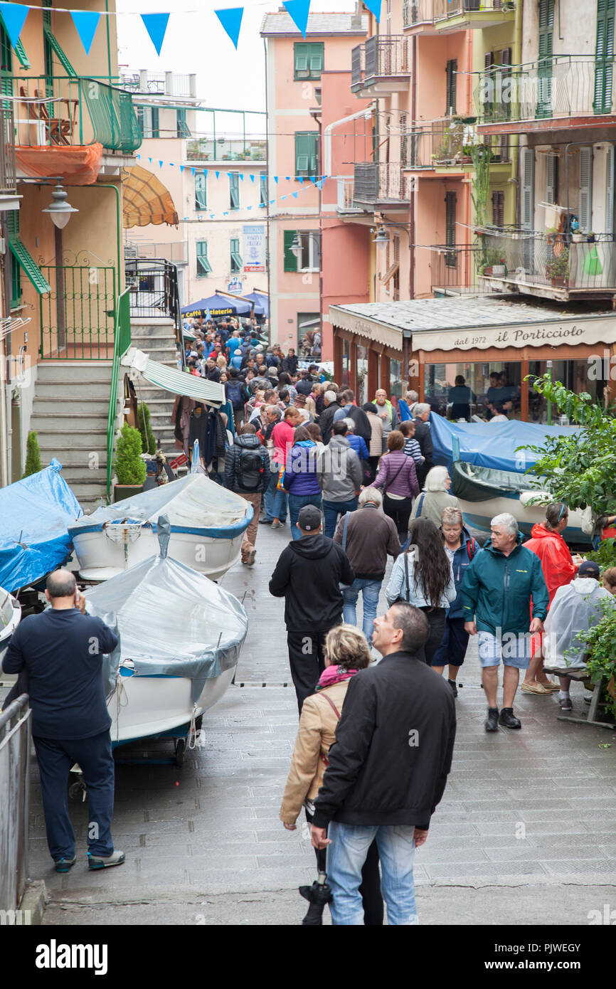 streets of Manarola, Italy crowded with tourists during the summer ...