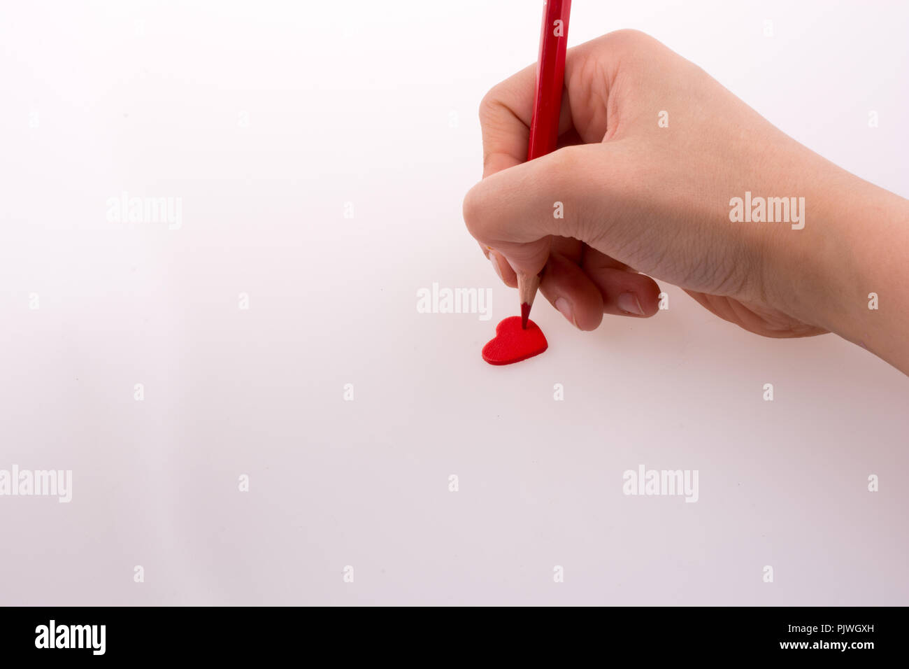 Pencil pointing a red heart Stock Photo - Alamy