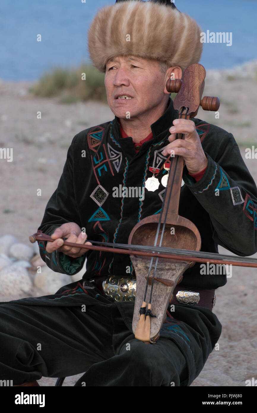 Issyk Kul, Kyrgyzstan / May 28, 2017 - Musician plays traditional Komuz ...