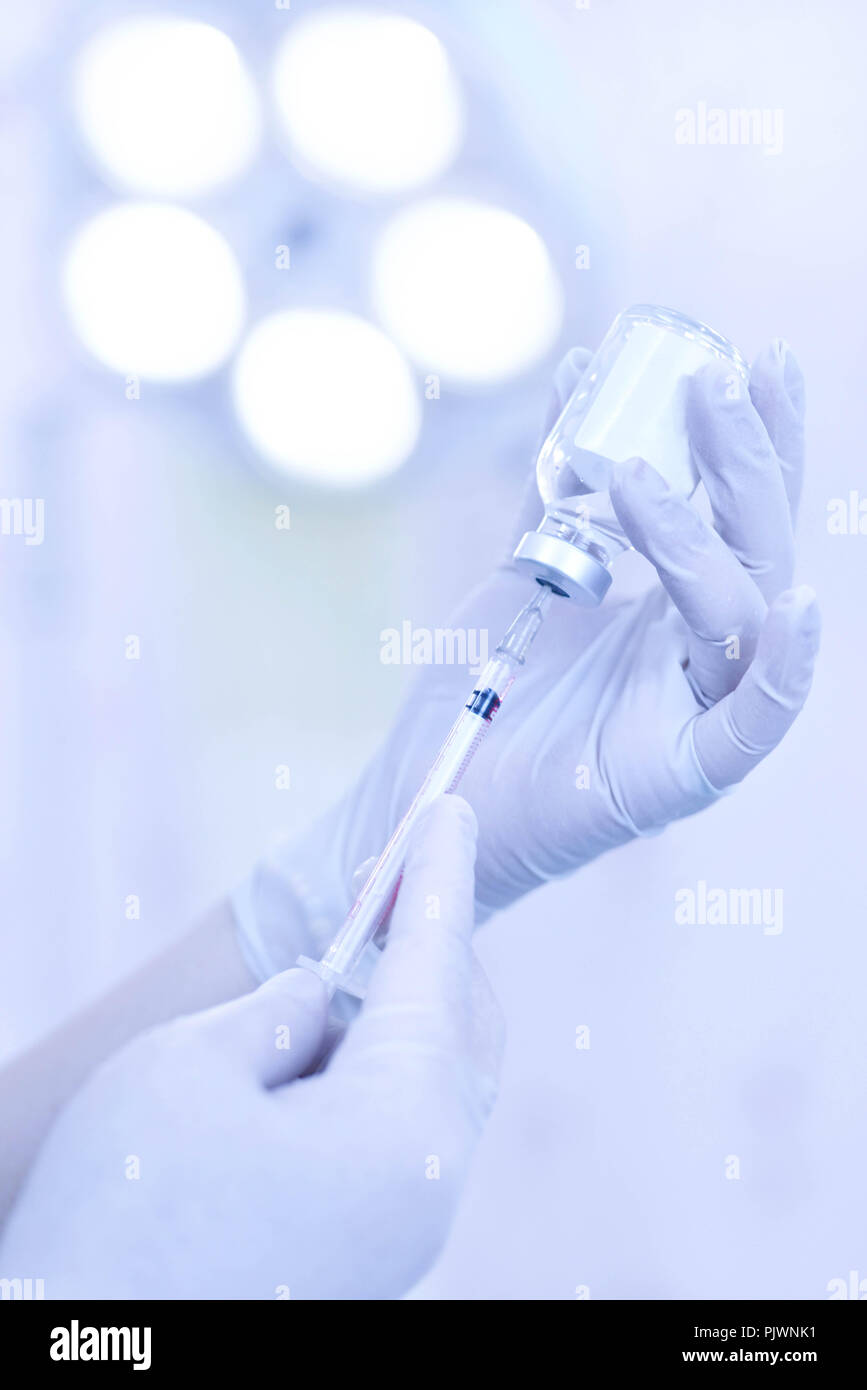Hand holding syringe and medicine vial prepare for injection in ...