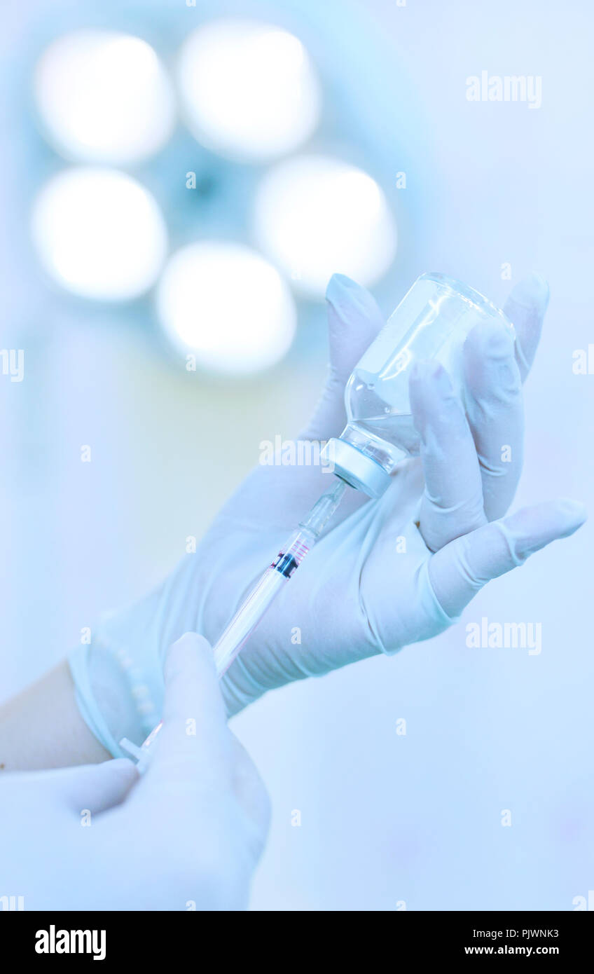 Hand holding syringe and medicine vial prepare for injection in ...