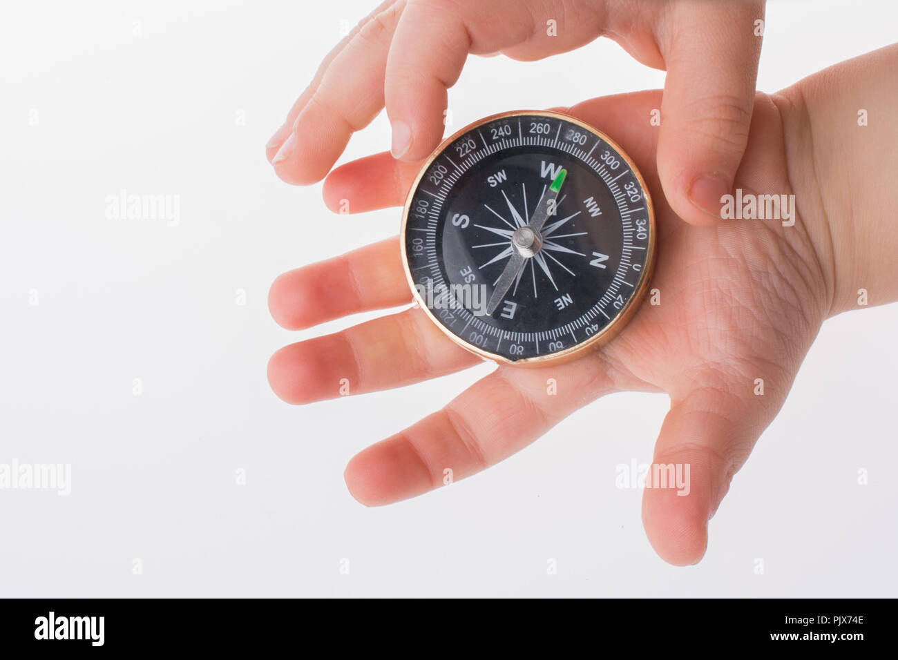 Child hand holding a compass on a white background Stock Photo - Alamy