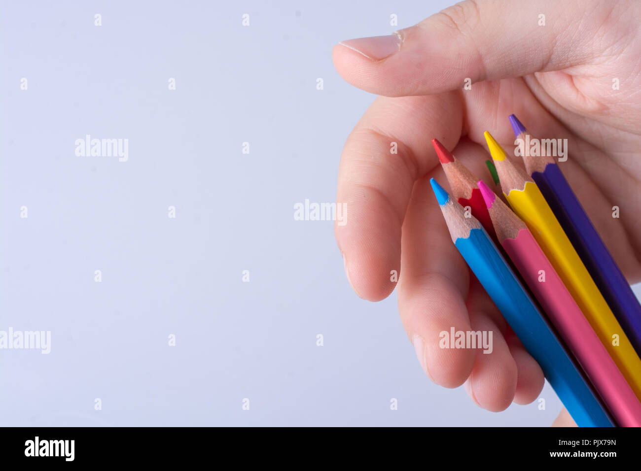 Hand holding color Pencils placed on a white background Stock Photo - Alamy