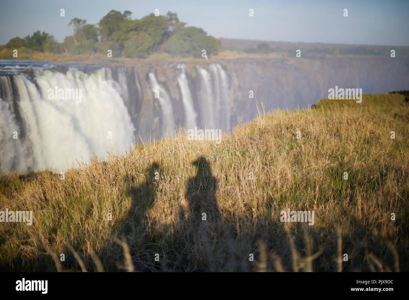 Shadow of tourists on grass, Victoria Falls, Zimbabwe Stock Photo - Alamy