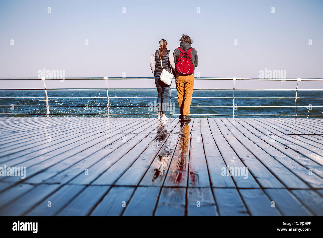 Couple looking out to sea Stock Photo - Alamy