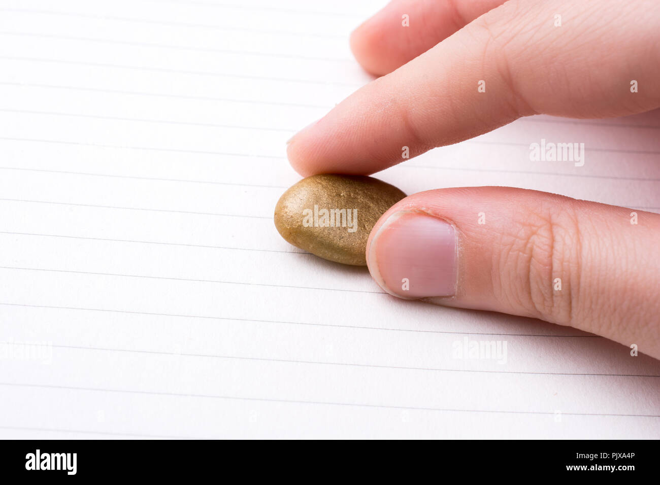 Little gold color pebble in the hand Stock Photo - Alamy