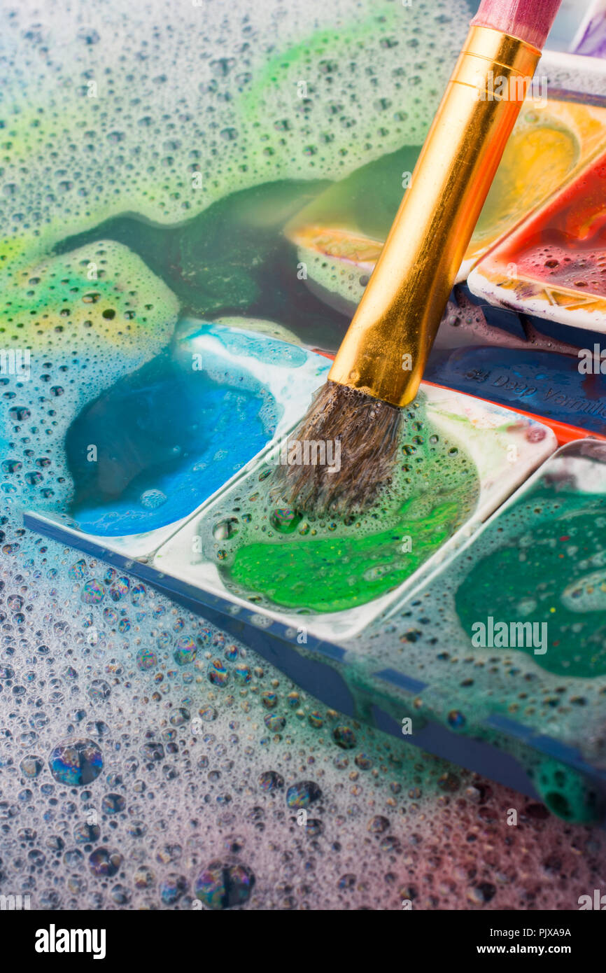 Watercolor paint dissolving in water covered with foam Stock Photo - Alamy