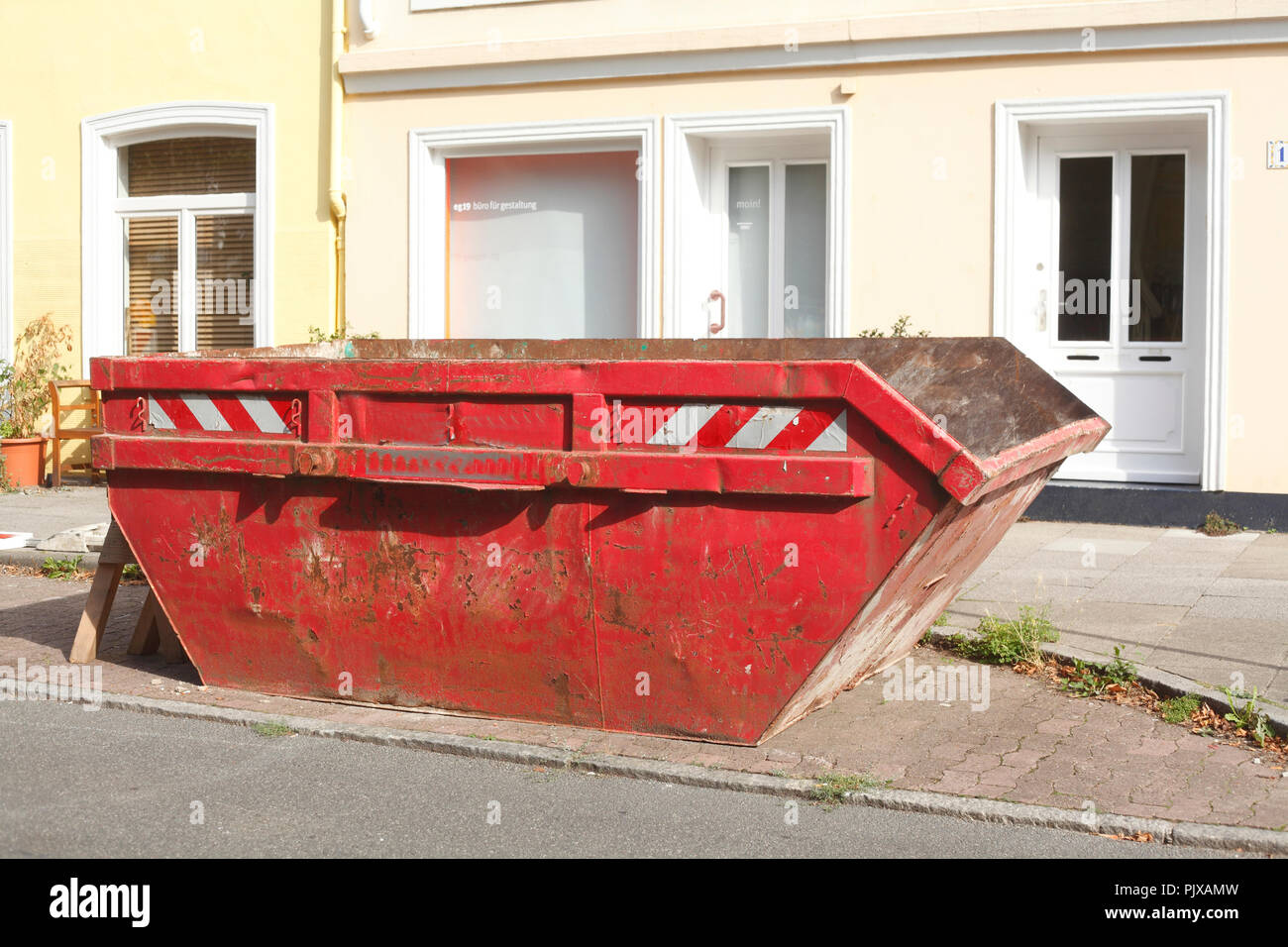 red Rubble Container on the street Stock Photo - Alamy