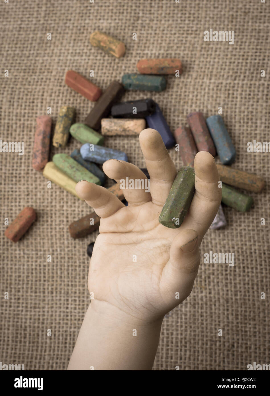 Used color crayons and a toddlers hand holding one Stock Photo - Alamy