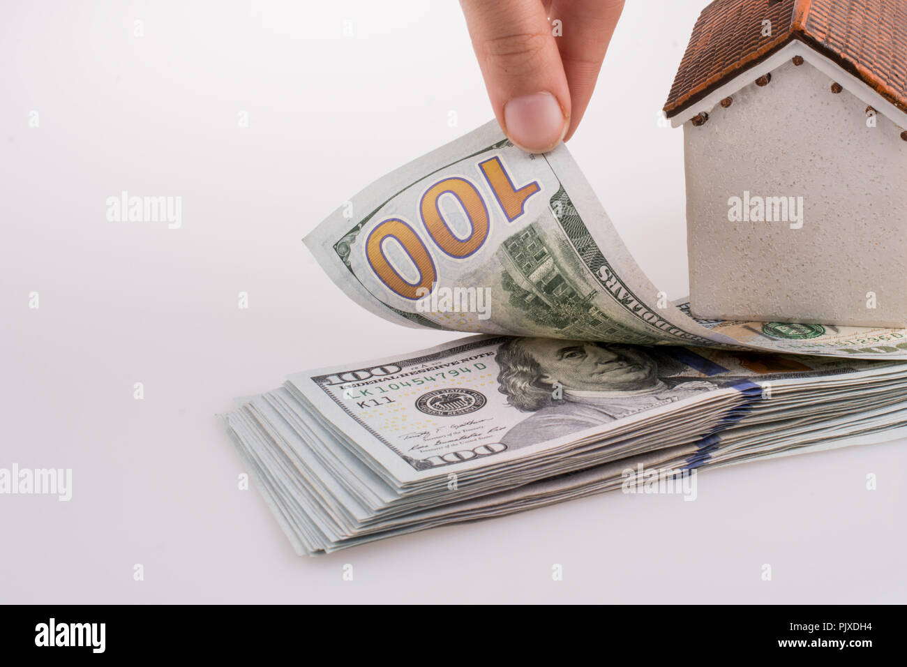 Human hand holding American dollar banknotes by the side of a model ...