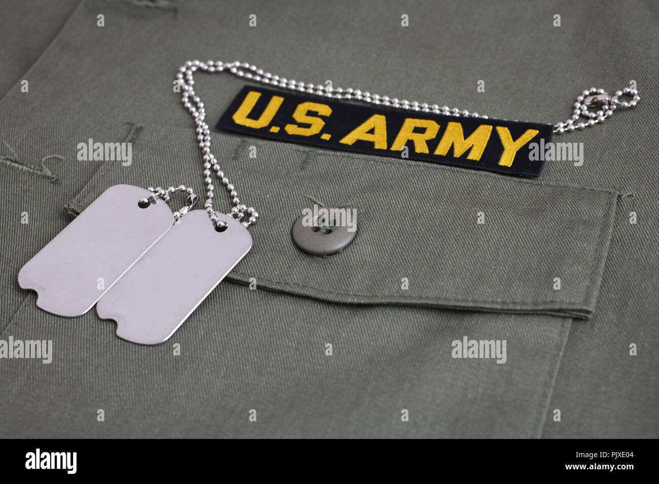 U.S. Army Branch Tape with dog tags on olive green uniform background ...
