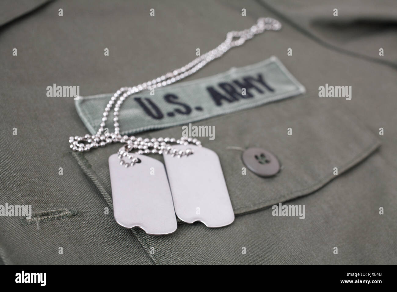U.S. Army Branch Tape with dog tags on olive green uniform background ...