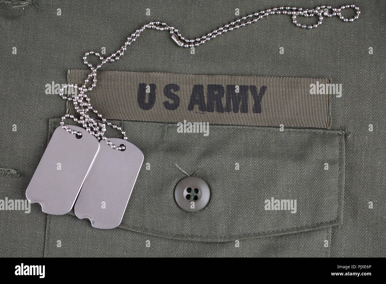 U.S. Army Branch Tape with dog tags on olive green uniform background ...