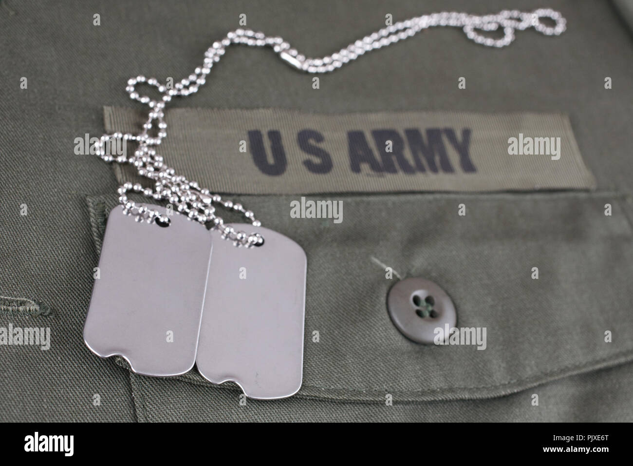 U.S. Army Branch Tape with dog tags on olive green uniform background ...