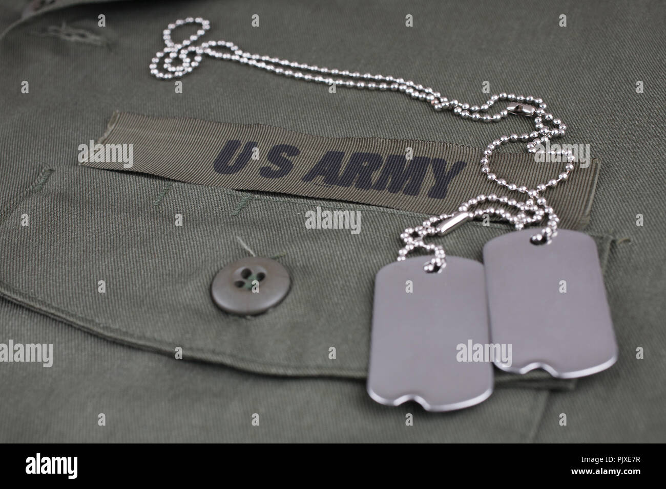 U.S. Army Branch Tape with dog tags on olive green uniform background ...